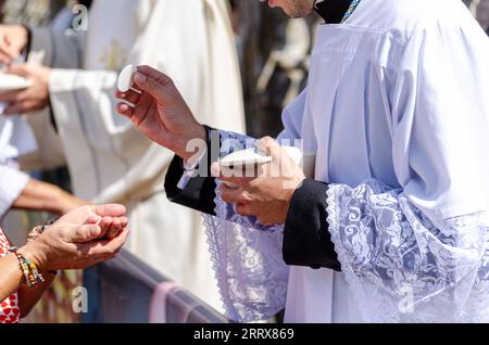 Selective focus, catholic priests distributing the communion wafer ...
