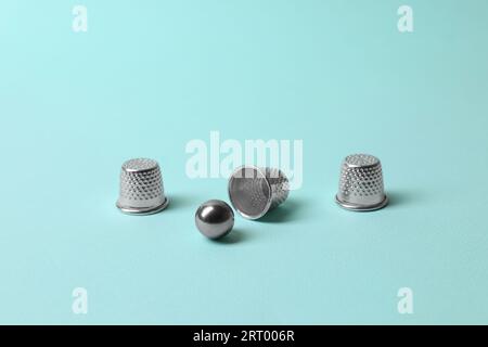 Metal thimbles and ball on light grey background. Thimblerig game Stock ...