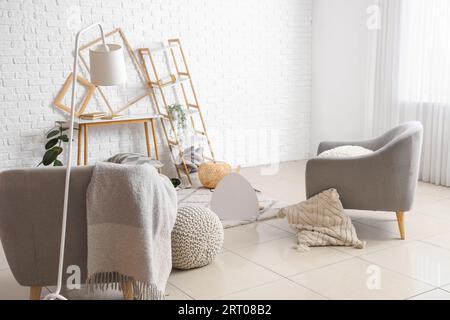 Tables with frames and shelving unit in messy living room Stock Photo ...