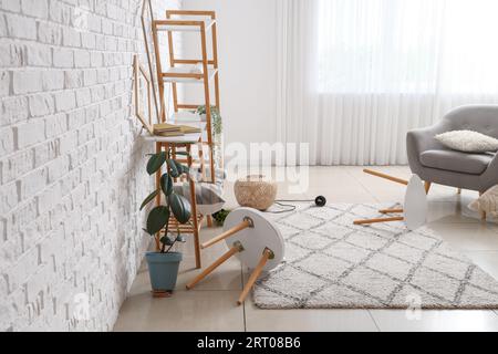 Tables with shelving unit in messy living room Stock Photo - Alamy