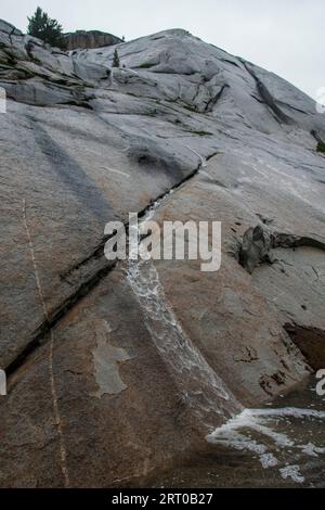 Temporary waterfalls form on the granite domes surrounding Tenaya Lake ...