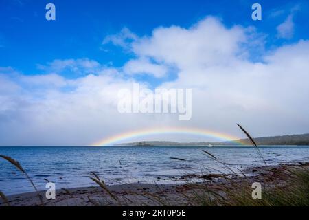 rainbow over the ovean and above an island in australia Stock Photo - Alamy
