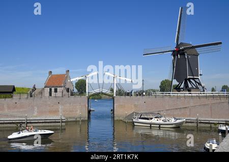 Harbor of Heusden with quay wall, white drawbridge, boats and mill ...