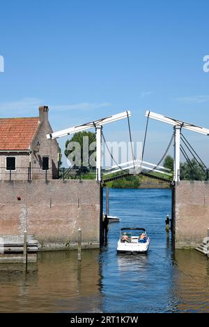 Harbor of Heusden with quay wall, white drawbridge, boats and mill ...