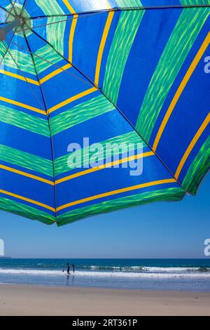 Getting shade under an brightly colored umbrella on Dockweiler State ...
