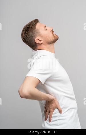 back view of man suffering from pain in neck isolated on white ...