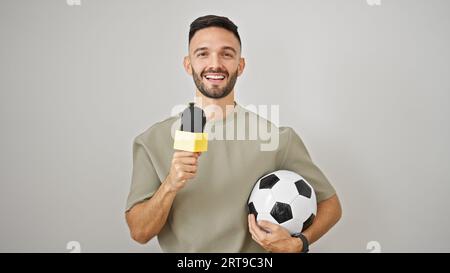Young hispanic man soccer reporter working using microphone holding ...
