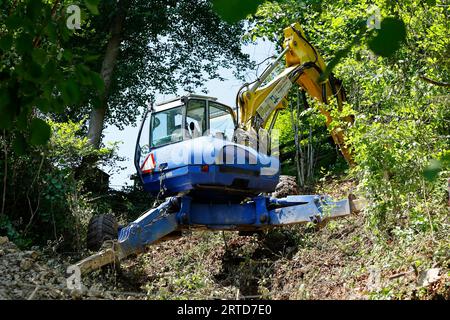 Excavator stands on a steep slope Stock Photo - Alamy