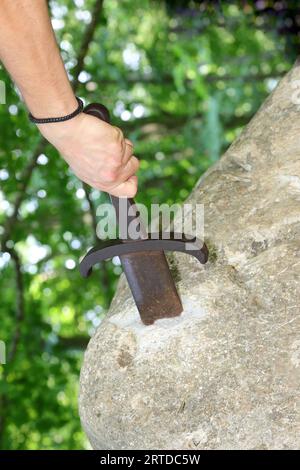 hand forcefully extracts the sword in the rock as in the mythological ...