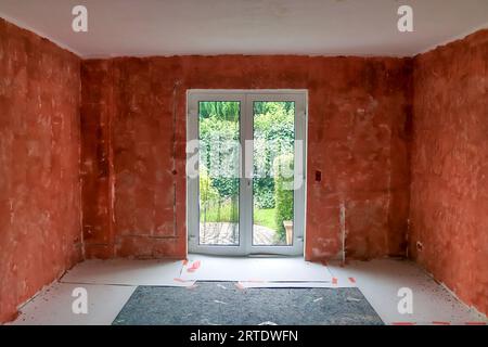 Renovation Of A Flat With Red Primer Paint On The Walls Stock Photo - Alamy