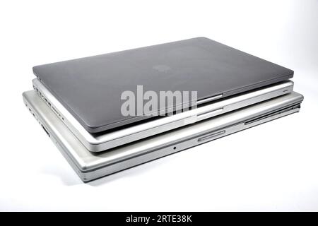 a stack or collection of 3 generations of Apple MacBook Pro laptop ...