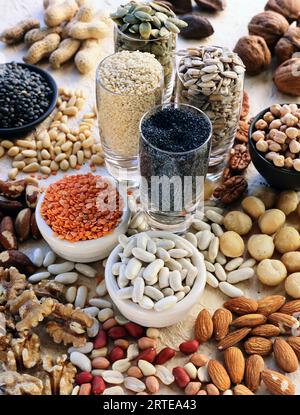 Various varieties of nuts and dried seeds lying in wooden box on brown ...