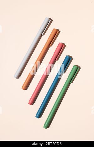 Some colourful pen arranging on beige Stock Photo - Alamy