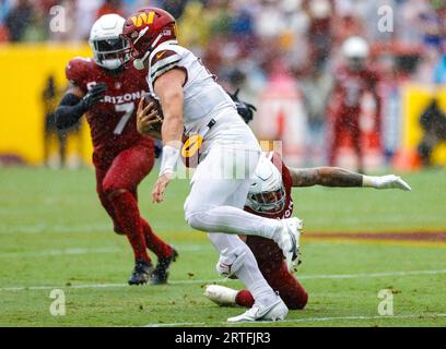 Washington Commanders QB Sam Howell (14) holding onto the ball as he is ...