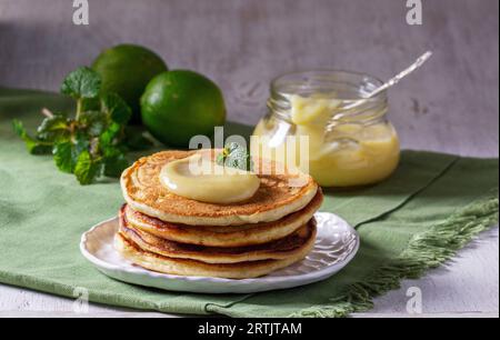 Whole grain flour fritters served with lime curd on a light background ...