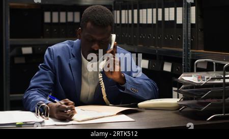 Police officer answers landline phone in incident room, receiving new ...