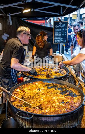 A Man Serves Paella At A Street Food Stall, Berwick Street, London, UK ...