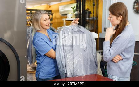 Worker giving woman her clean clothes Stock Photo - Alamy