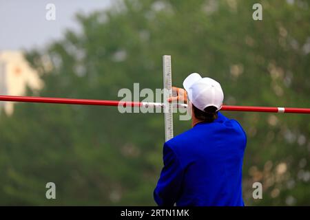 high jump field staff are adjusting the height Stock Photo - Alamy