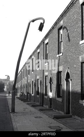 1960s, historical, outside in street of victorian terraced cottages, a ...