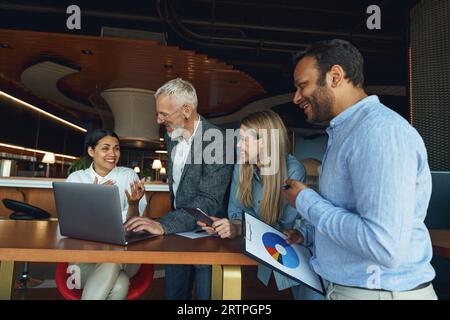 Group of people discussing daily plans in the office using laptop. Business teamwork situation ...