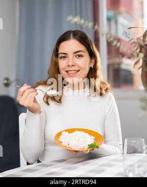 Emotional young woman eating rice at home Stock Photo - Alamy