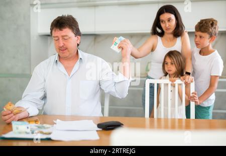 Father gives pocket money to children and wife Stock Photo - Alamy