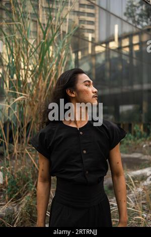 Hispanic man with long hair standing over blue background smiling ...