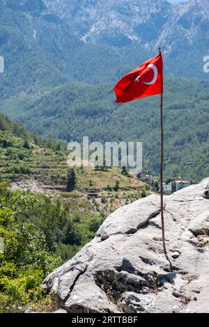 The Turkish flag is flying against the backdrop of beautiful mountains ...
