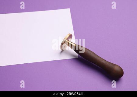 One stamp tool and sheet of paper on light brown background Stock Photo ...