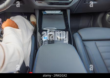 Beautiful interior view of electric car BMW iX40 on road. Woman driver ...