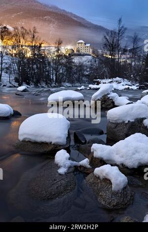 The Noce stream and the medieval castle of Caldes on a winter night ...