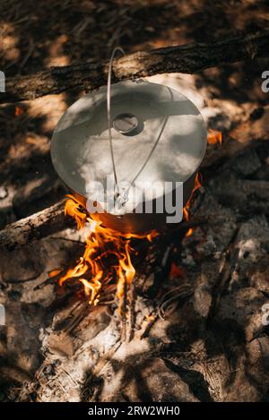 Tourist pot of water hanging over a fire of wood in the Camping Stock ...