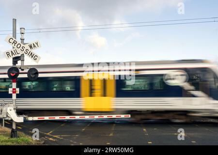 Auckland Transport Kiwirail electric train at rail crossing in Onehunga ...