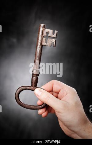 Man holding a big old antique skeleton key in his hand Stock Photo - Alamy