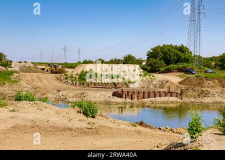 Installed metal piles along river bank, build in for bridge foundation ...