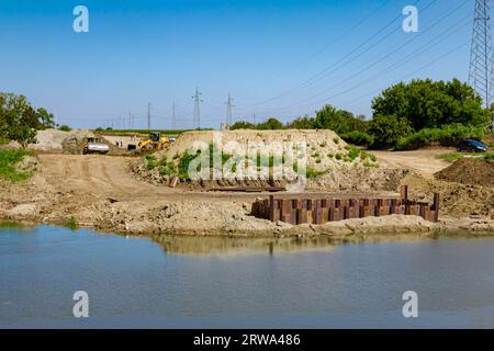Installed metal piles along river bank, build in for bridge foundation ...