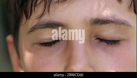 Pensive young boy closing eyes in contemplation. Thoughtful child ...