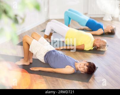 Family generation doing Half bridge pose Stock Photo - Alamy