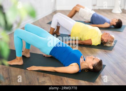 Family generation doing Half bridge pose Stock Photo - Alamy