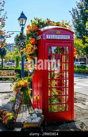 Red, English Phone booth, adorned with flowers Stock Photo - Alamy