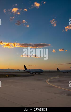 The sunset over Denver Airport, reflecting in the metal airplane wing ...