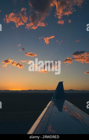 The sunset over Denver Airport, reflecting in the metal airplane wing ...