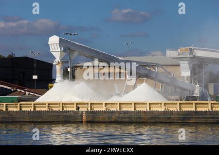 Piles of fresh salt waiting for transportation at river waterfront ...
