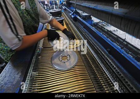 Workers replace shuttle cores at a fishing net processing plant, China ...