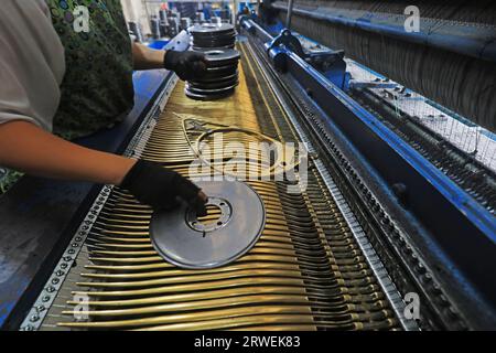 Workers replace shuttle cores at a fishing net processing plant, China ...