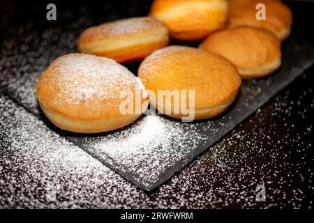 German Krapfen with drizzling glazed sprinkles in black elegant ...