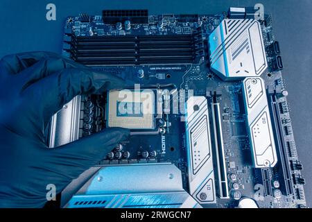 a computer processor in a gloved hand against the background of the ...