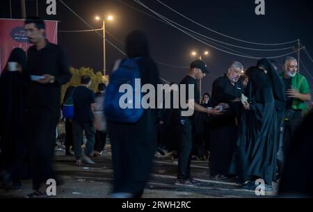 Iraqi Shia Muslims distribute food among Shia Muslim pilgrims marching ...