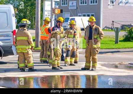 Firefighters in protective gear are responding to a building fire, with ...